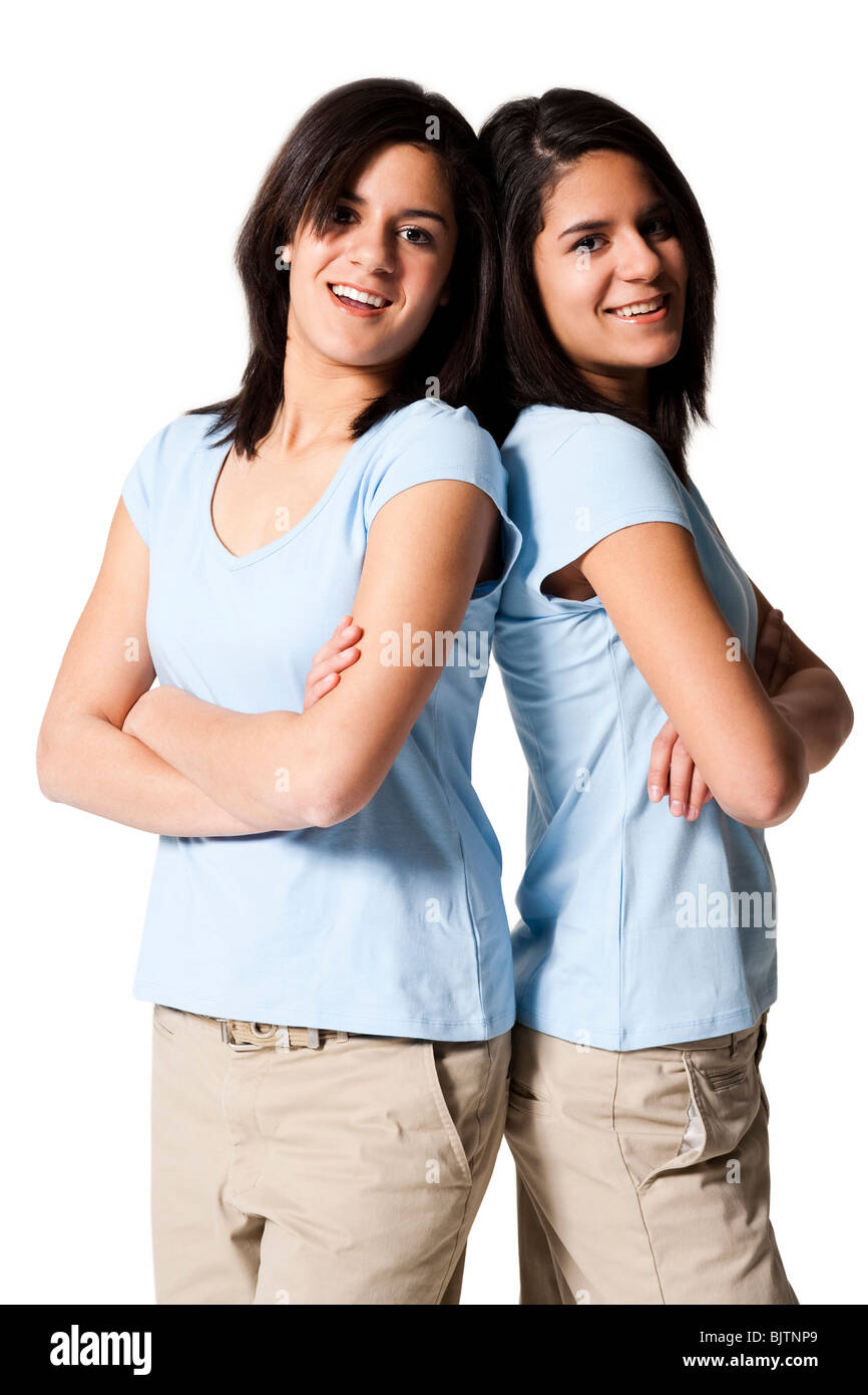 Sisters back to back with arms crossed Stock Photo - Alamy