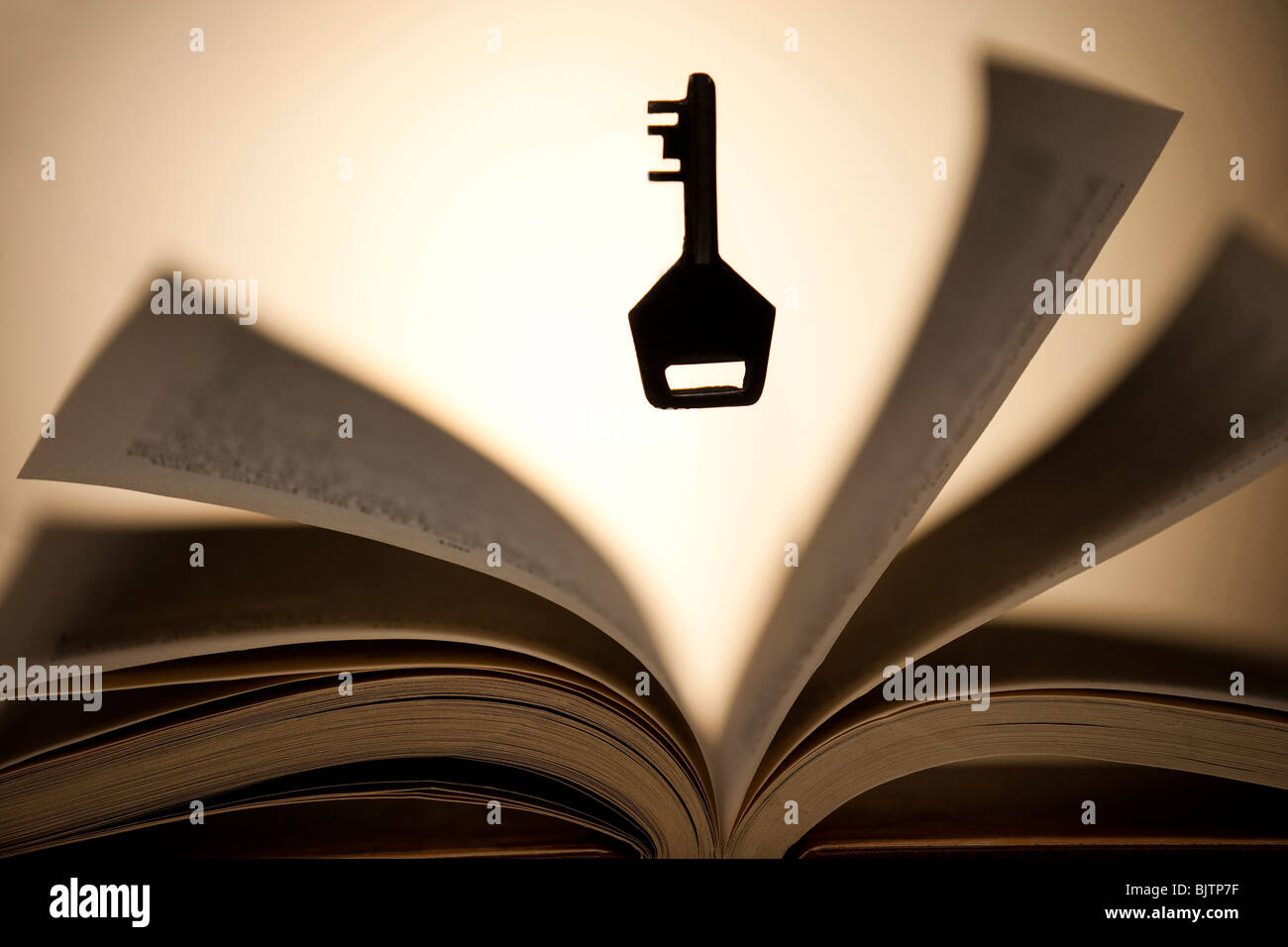 Key hovering above open book Stock Photo - Alamy
