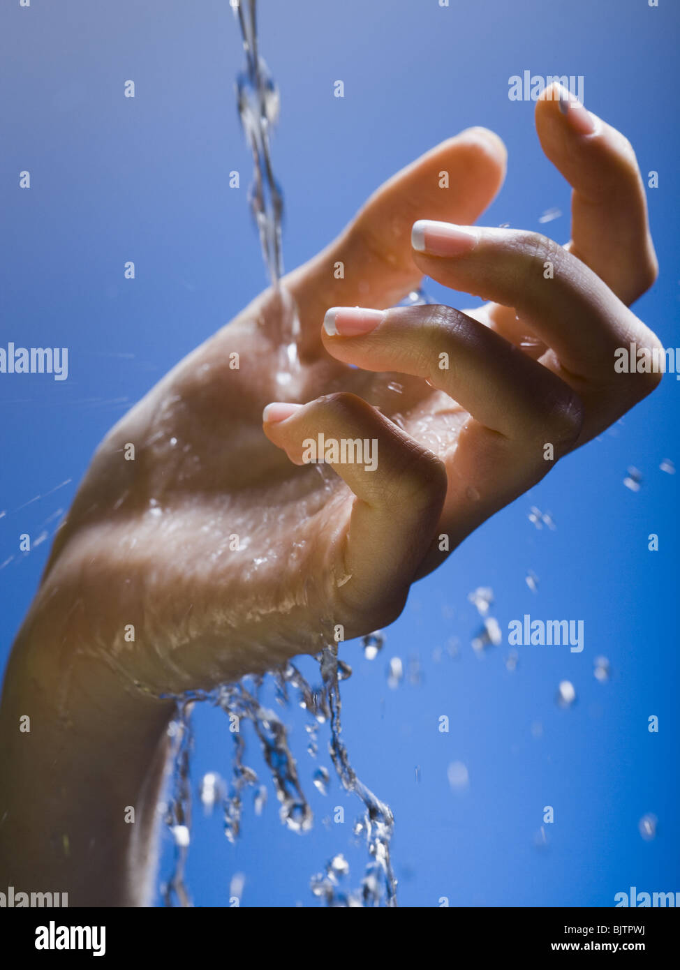 Hand catching falling stream of water Stock Photo - Alamy