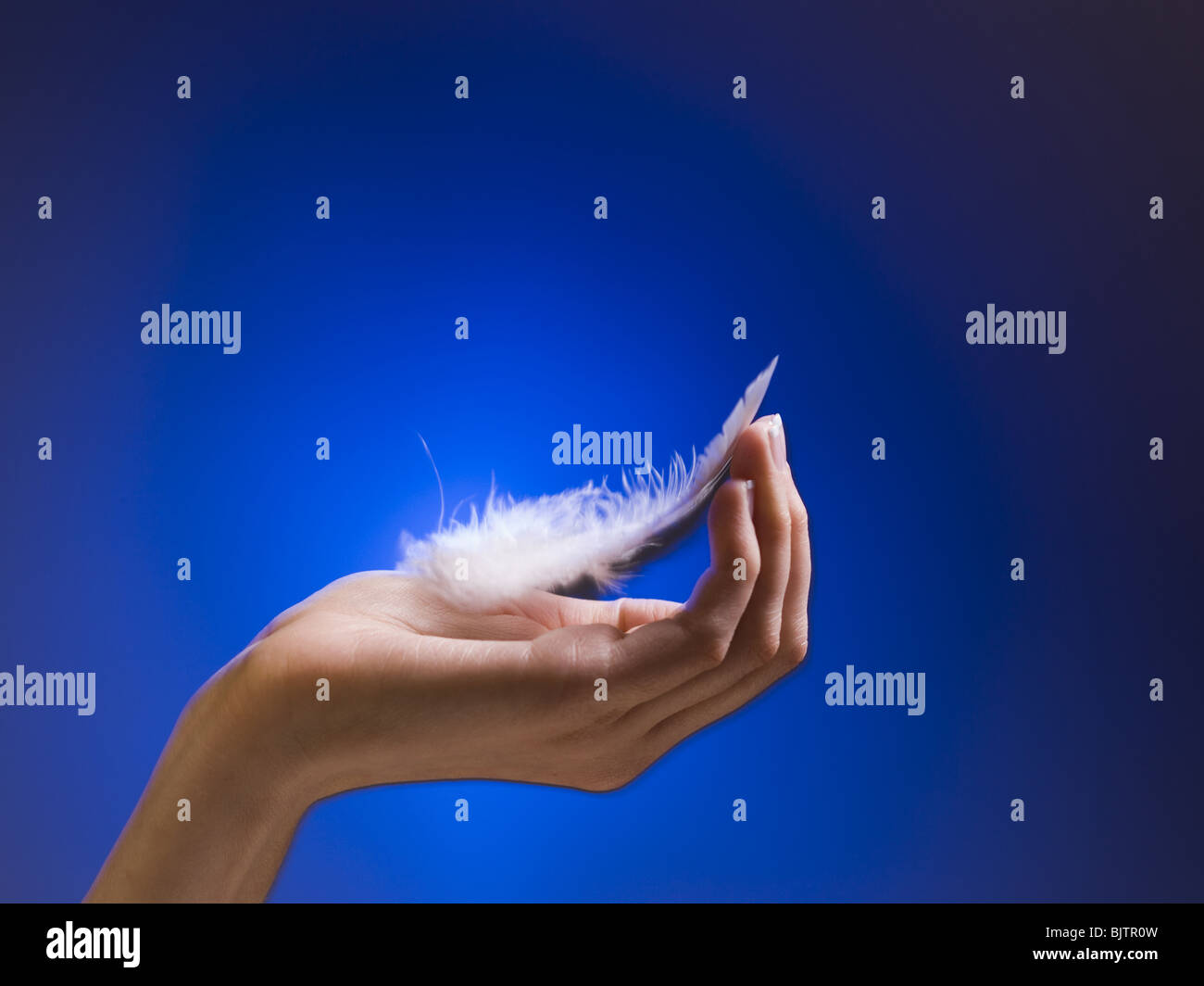 Hand with floating feather Stock Photo - Alamy