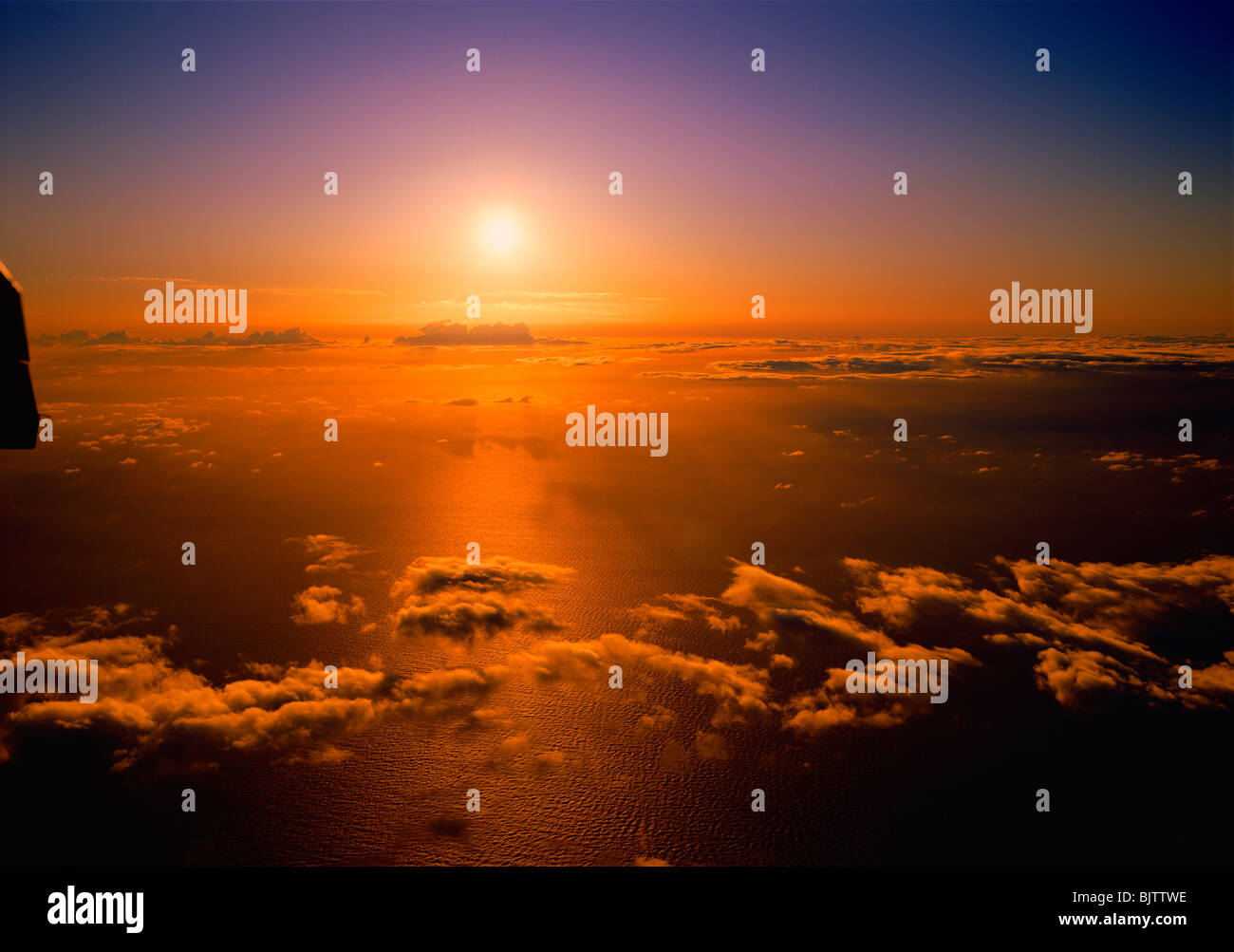 Sunset over clouds Stock Photo - Alamy