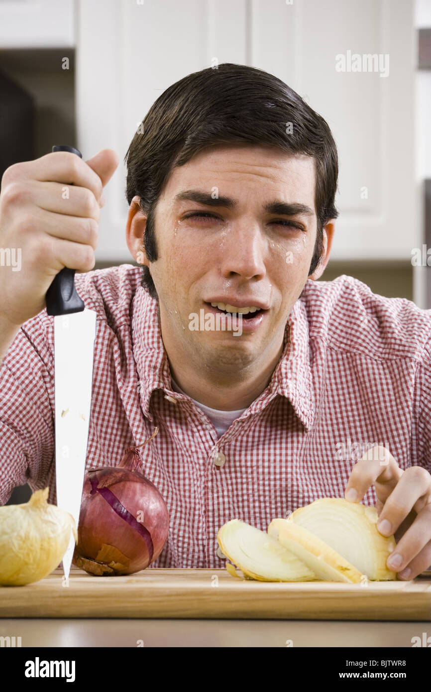 Man slicing onion and crying Stock Photo - Alamy