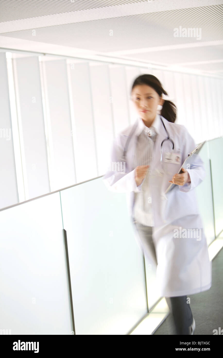 Doctor running with chart through hallway Stock Photo - Alamy