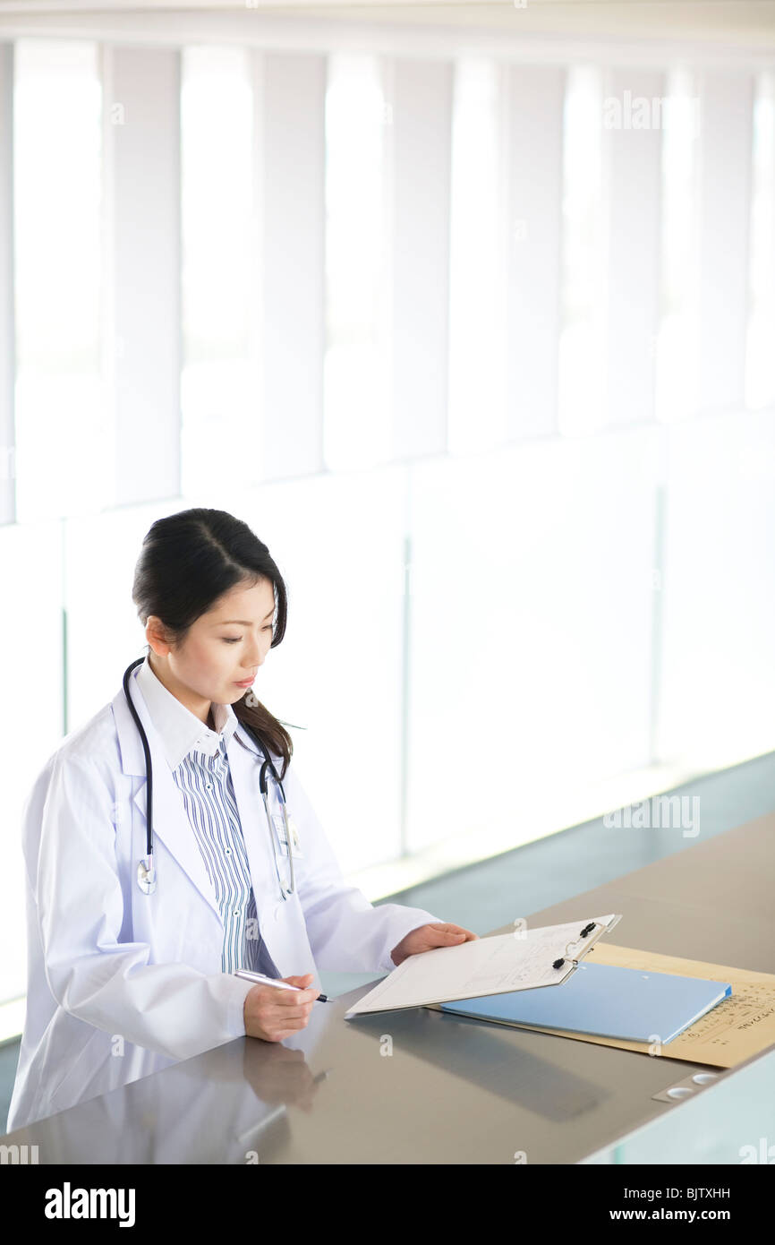 Doctor signing paperwork Stock Photo - Alamy
