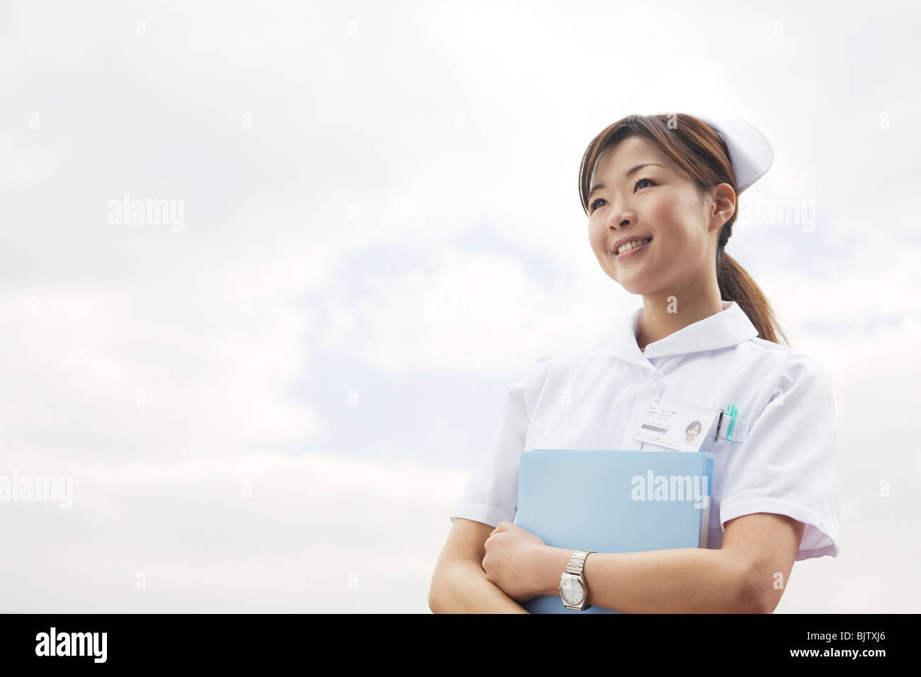 Nurse standing outside holding file Stock Photo - Alamy
