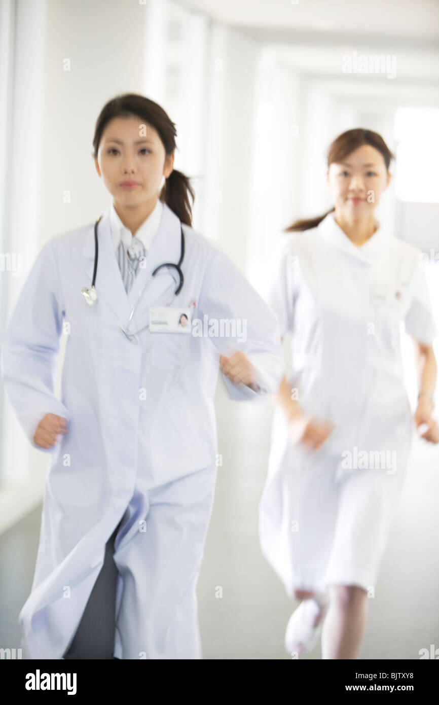 Doctor and nurse running through hospital Stock Photo - Alamy
