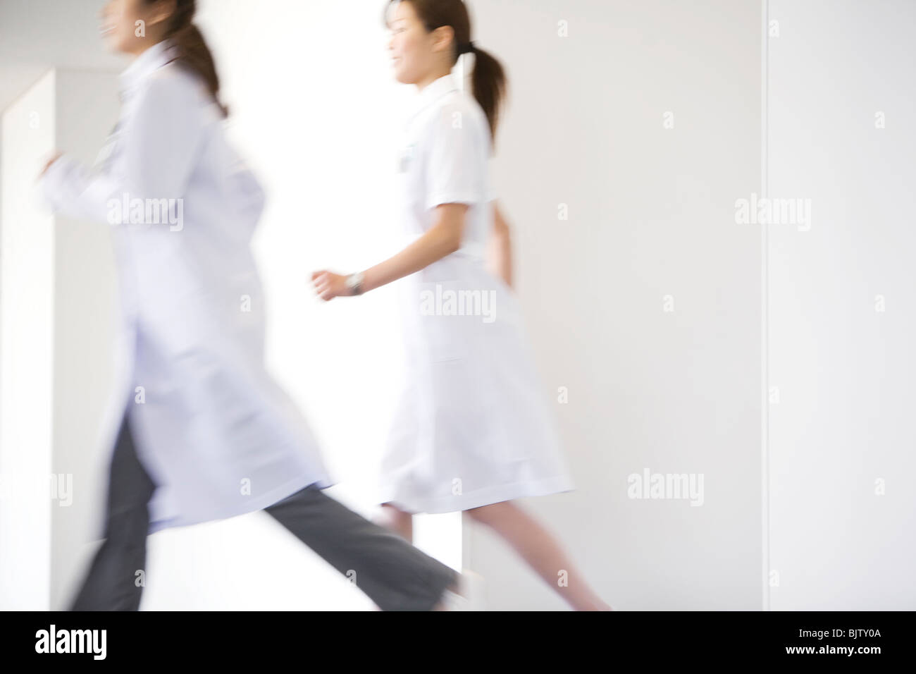Doctor and nurse running through hospital Stock Photo - Alamy