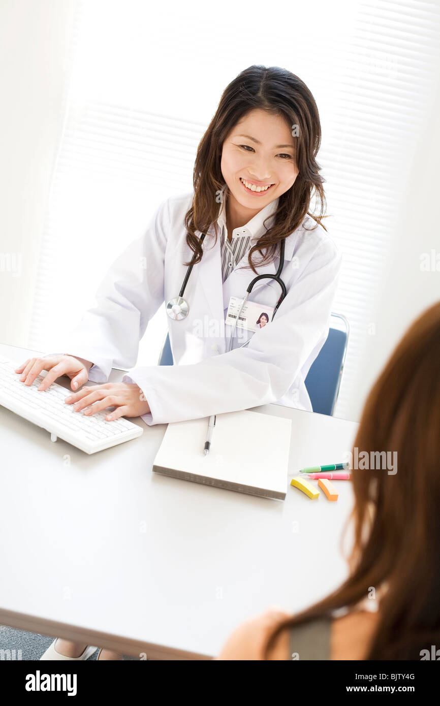 Female doctor giving a consultation to a patient Stock Photo - Alamy