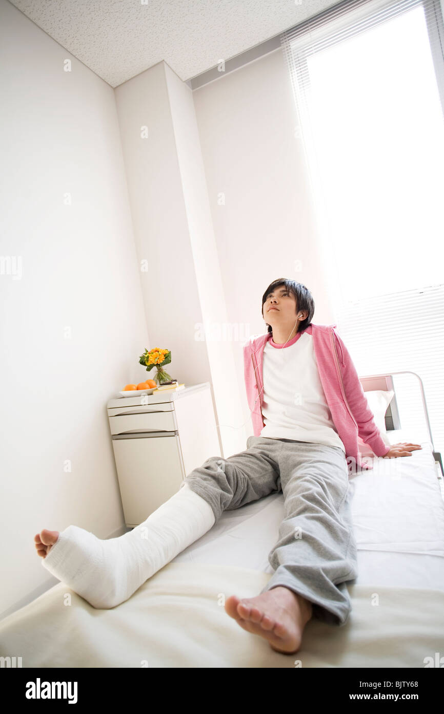 Man with broken leg sitting on a hospital bed Stock Photo - Alamy