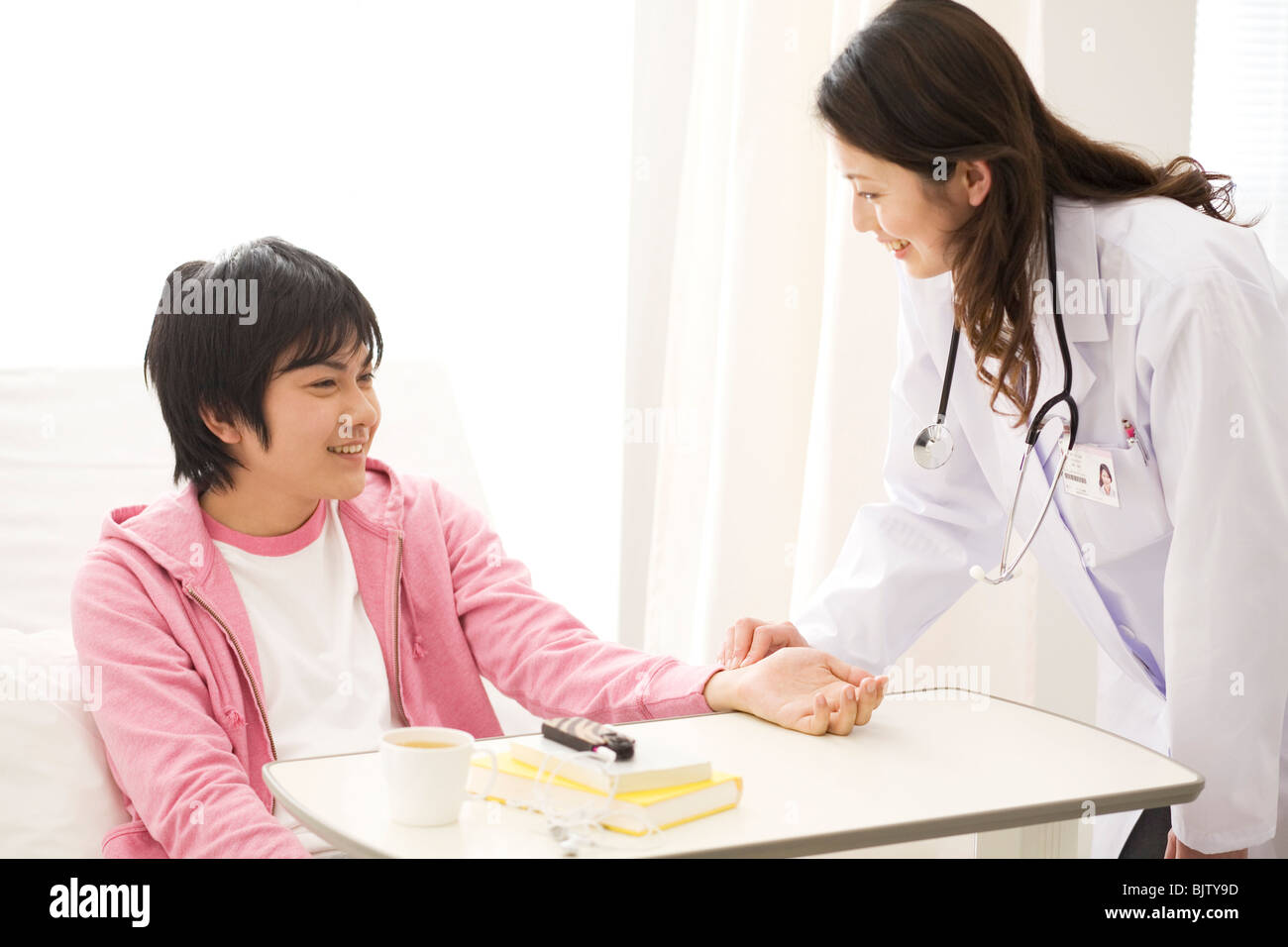 Female doctor taking a man's pulse Stock Photo - Alamy