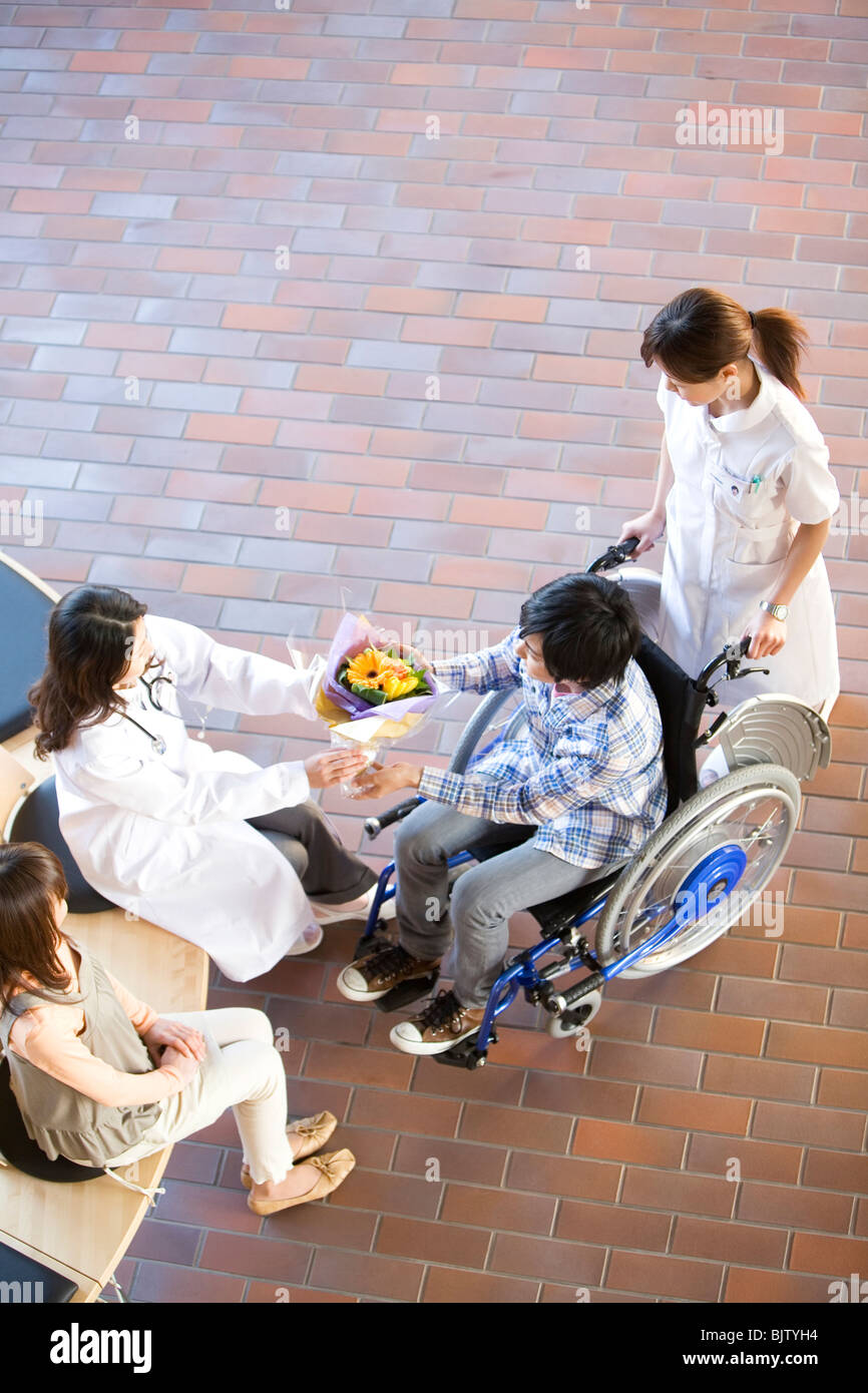 Doctor giving patient a bunch of flowers as he leaves hospital Stock ...