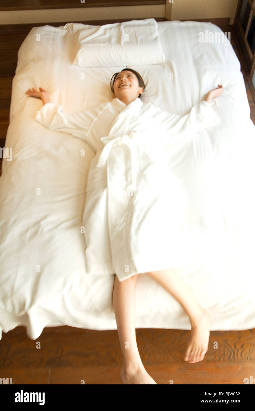 Woman lying on a bed Stock Photo - Alamy