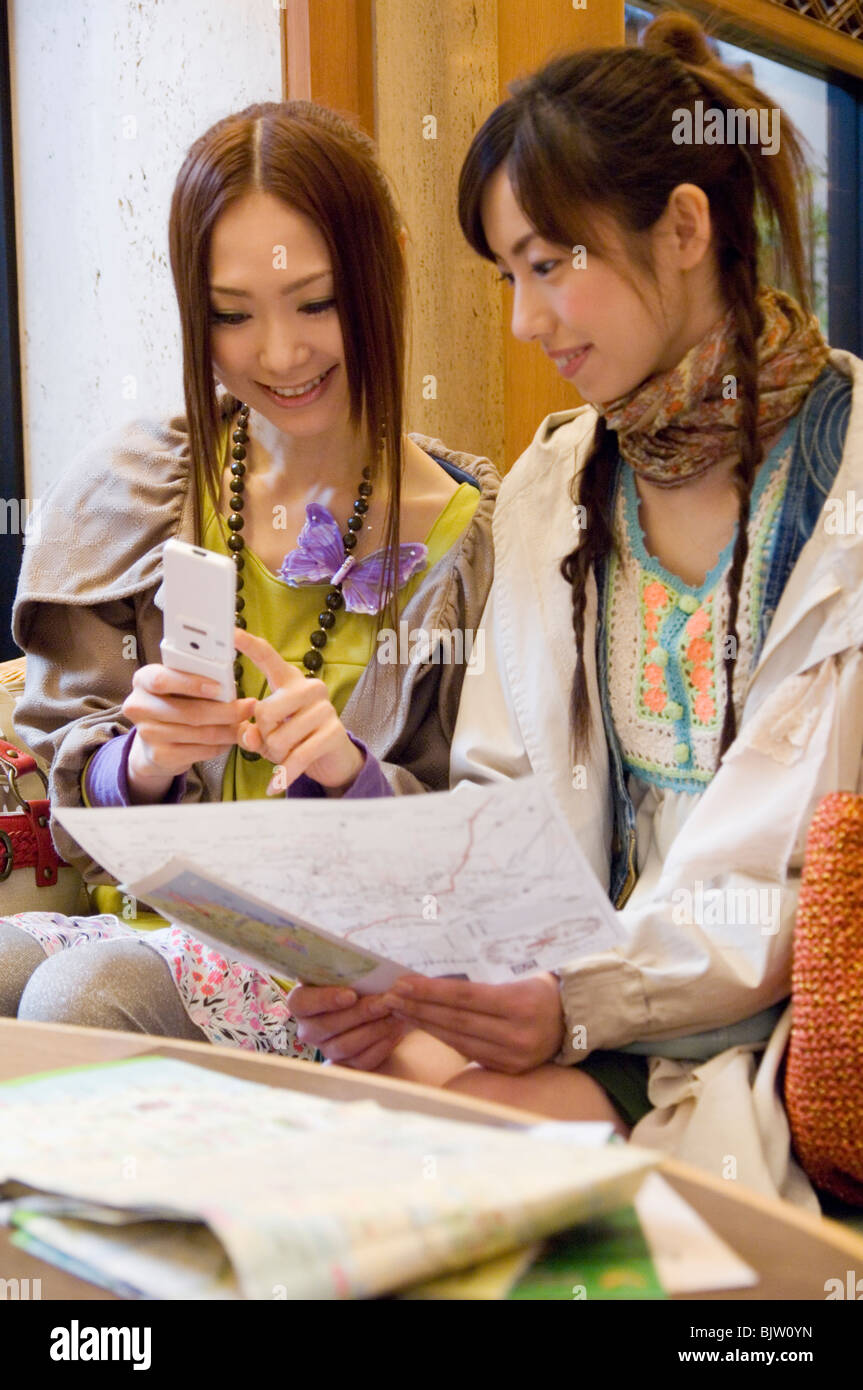 Two friends planning their travels in a hotel lobby Stock Photo - Alamy