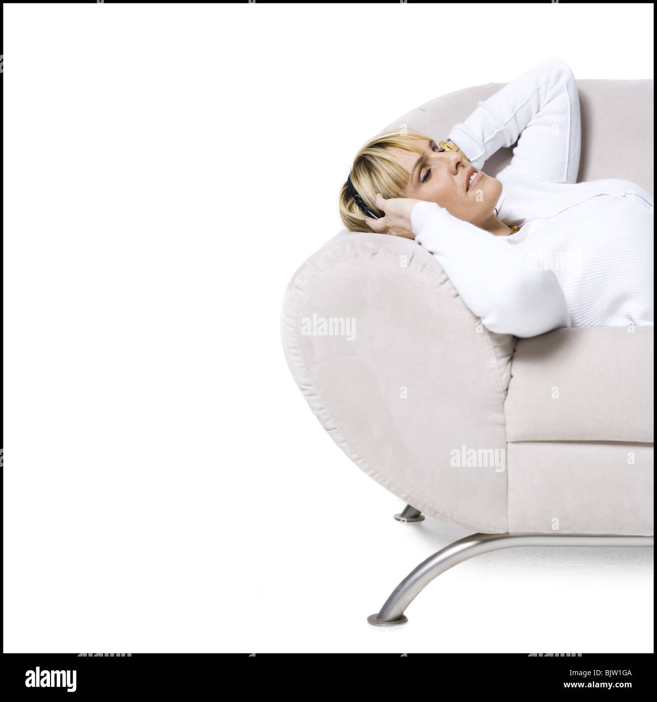 Woman smiling resting on couch Stock Photo - Alamy