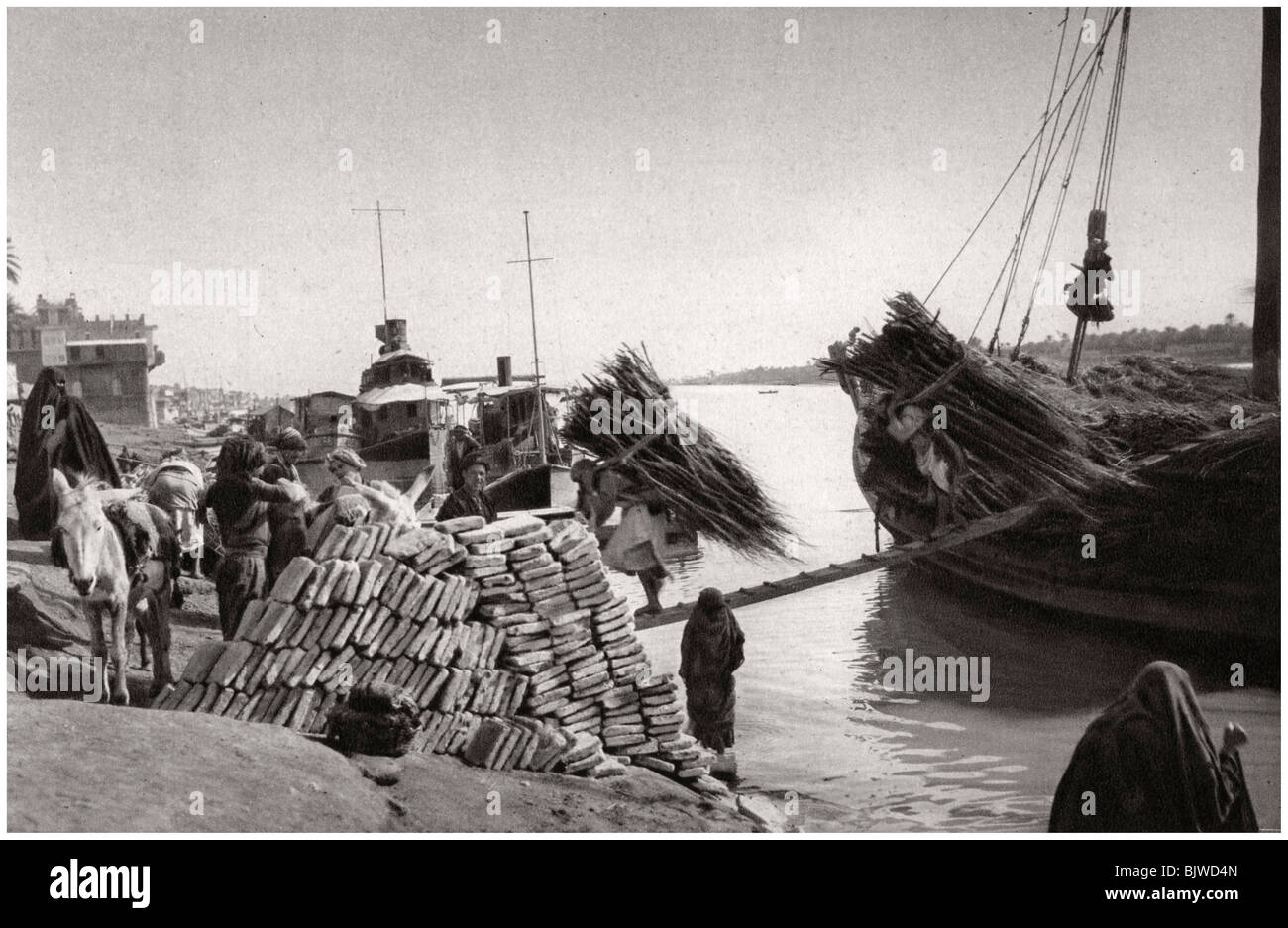 Unloading cargo from a boat, Muhaila, Baghdad, Iraq, 1925.Artist: A ...