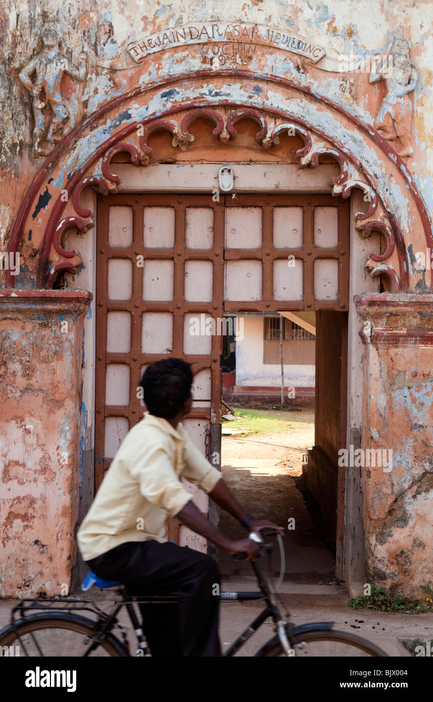 India, Kerala, Kochi, Fort Cochin, Fosse Street, man cycling past 1920s ...