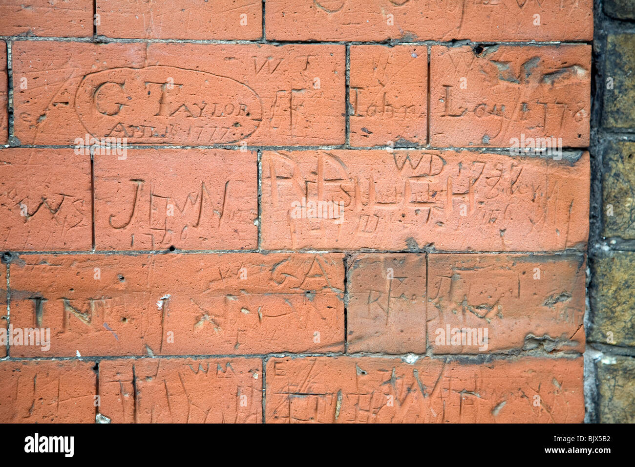 Eighteenth century graffiti scratched on brick wall of school building ...