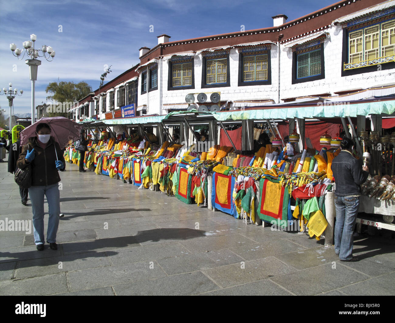 Vendors sell colorful Buddhist prayer flags in stalls lining Barkor ...