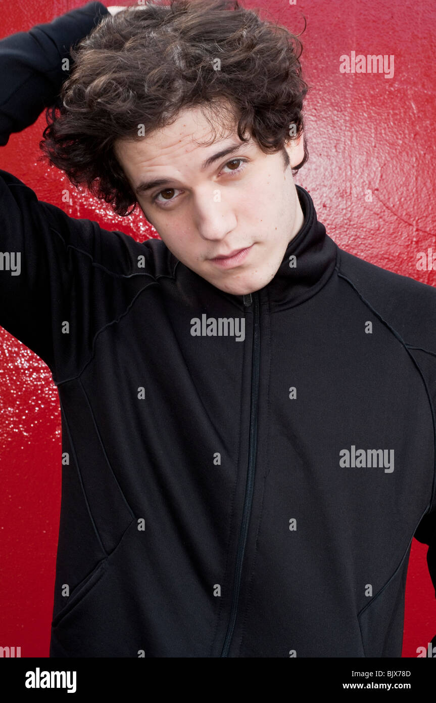 Portrait of young man running his fingers through his hair with red ...