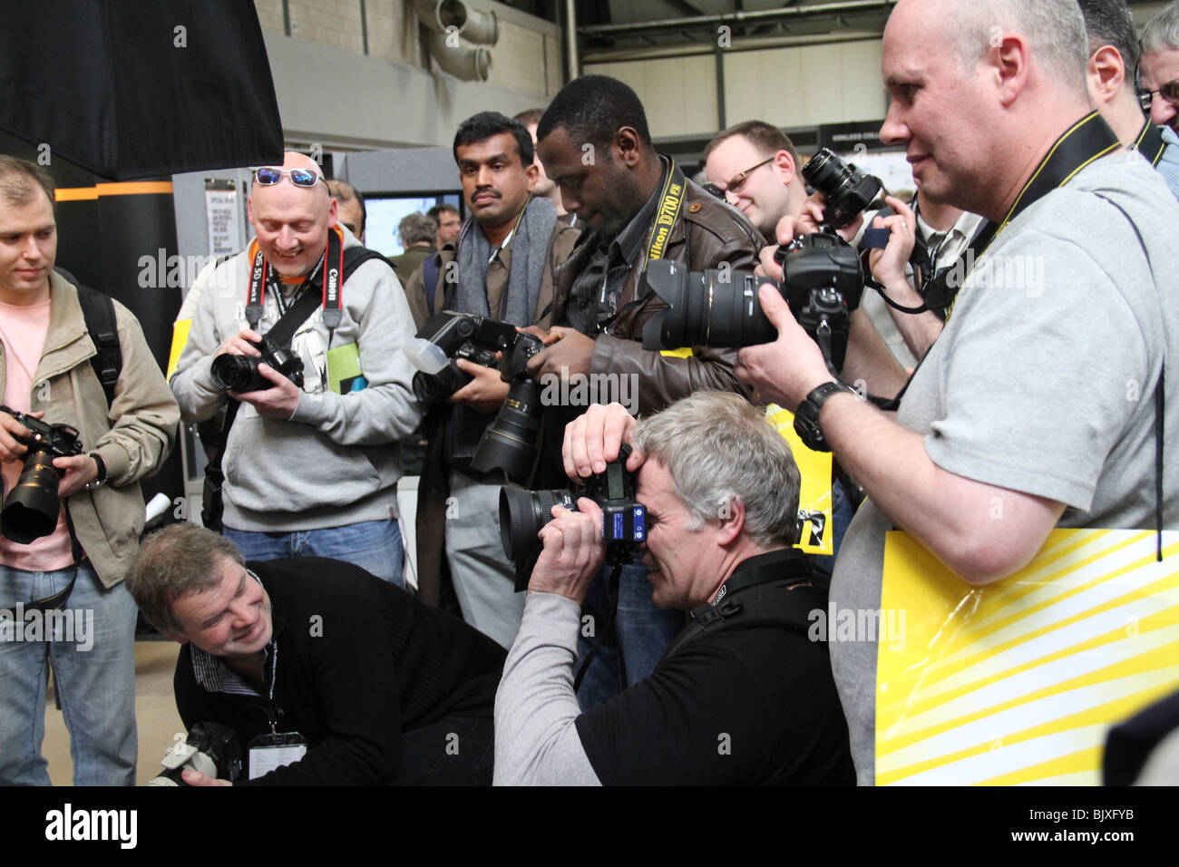People at a photographic show testing and inspecting new equipment ...
