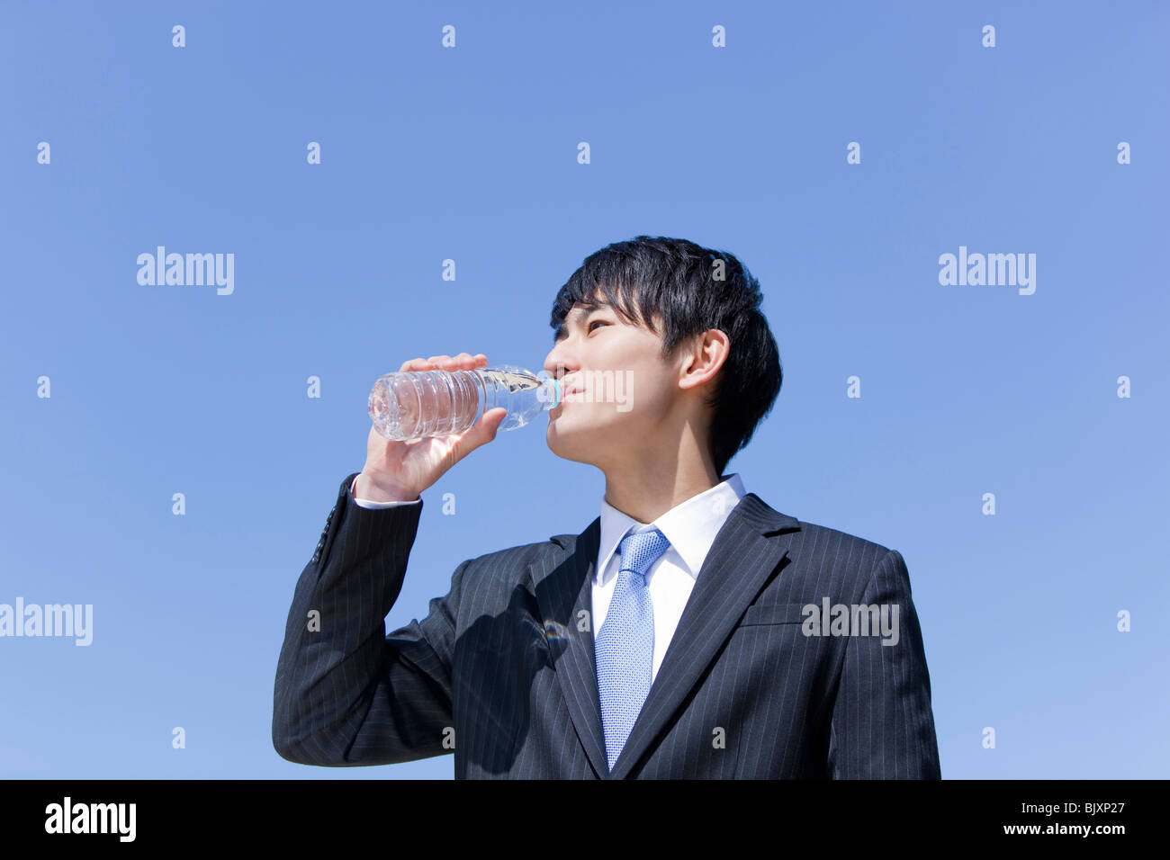 Young businessman drinking mineral water Stock Photo - Alamy