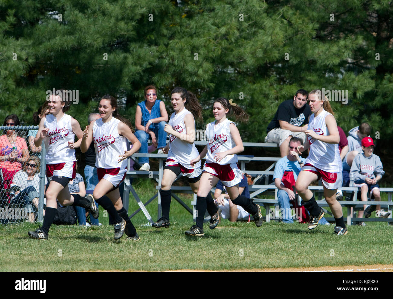 A group of high school girls running. School softball players working ...