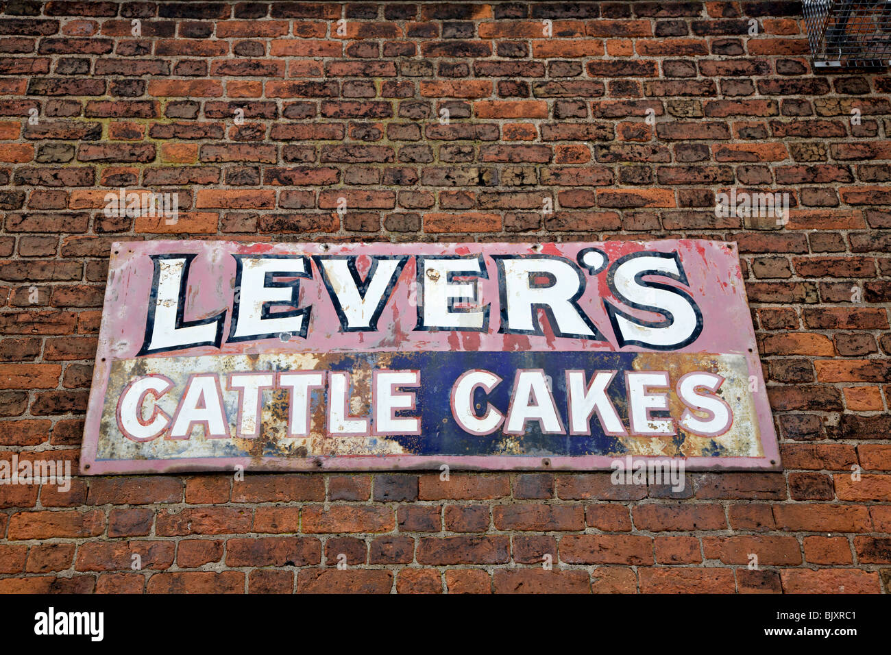 old fashioned metal product sign on wall at disused Hadlow Rd train ...
