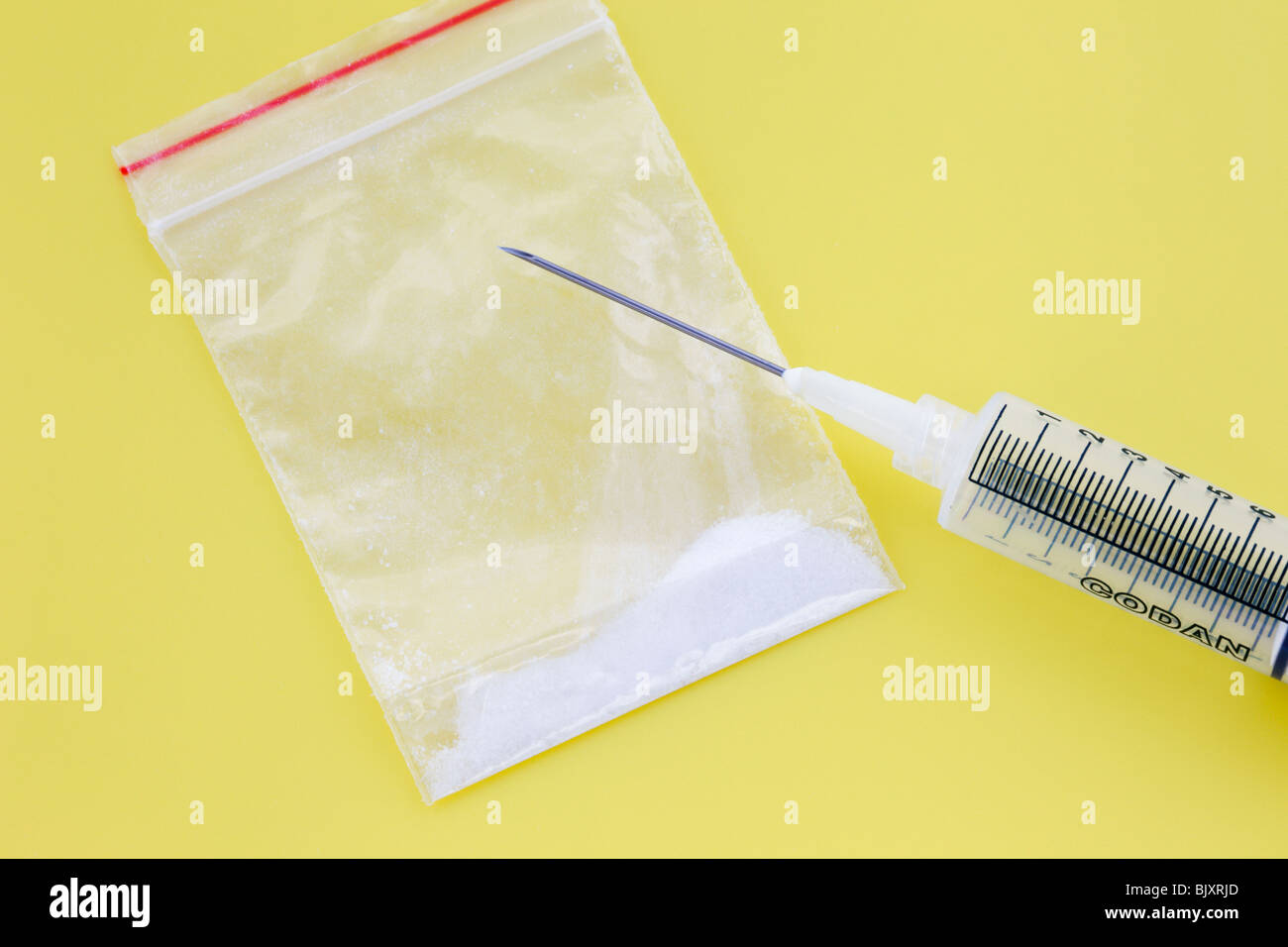 Powdered drugs wrap and syringe for injecting Stock Photo - Alamy