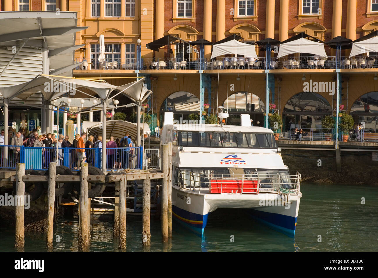 Auckland, New Zealand. Fullers Ferry passengers on wharf on Waitemata ...