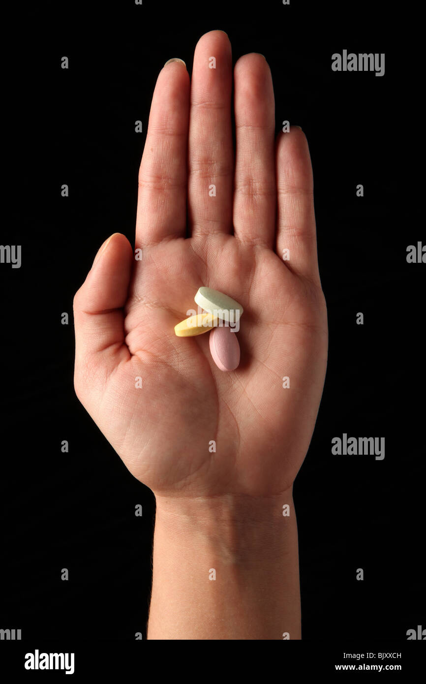 A female woman's hand holding three pills in the palm of her hand Stock ...