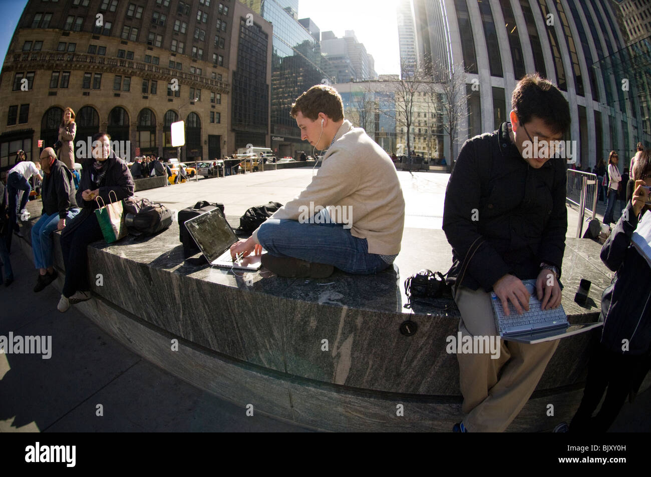 People using laptops outside the Apple store on Fifth Avenue at the ...
