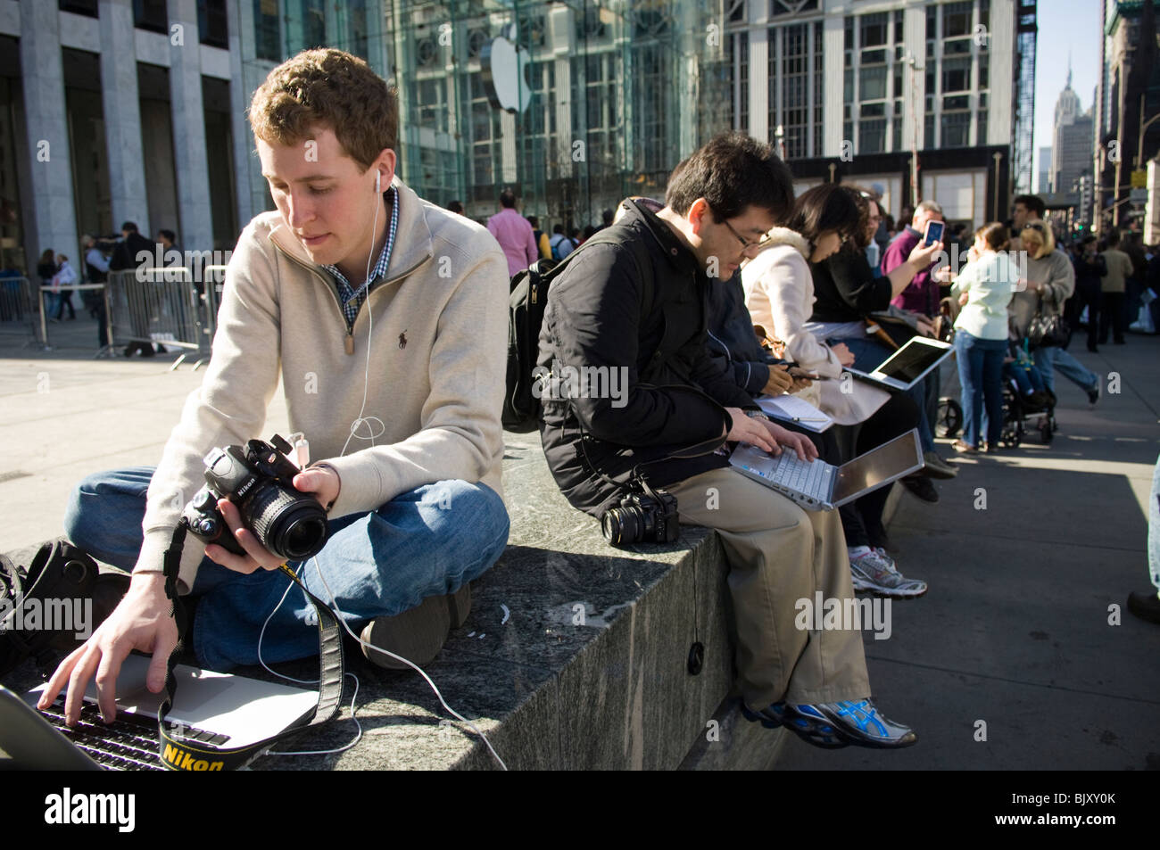 People using laptops outside the Apple store on Fifth Avenue at the ...