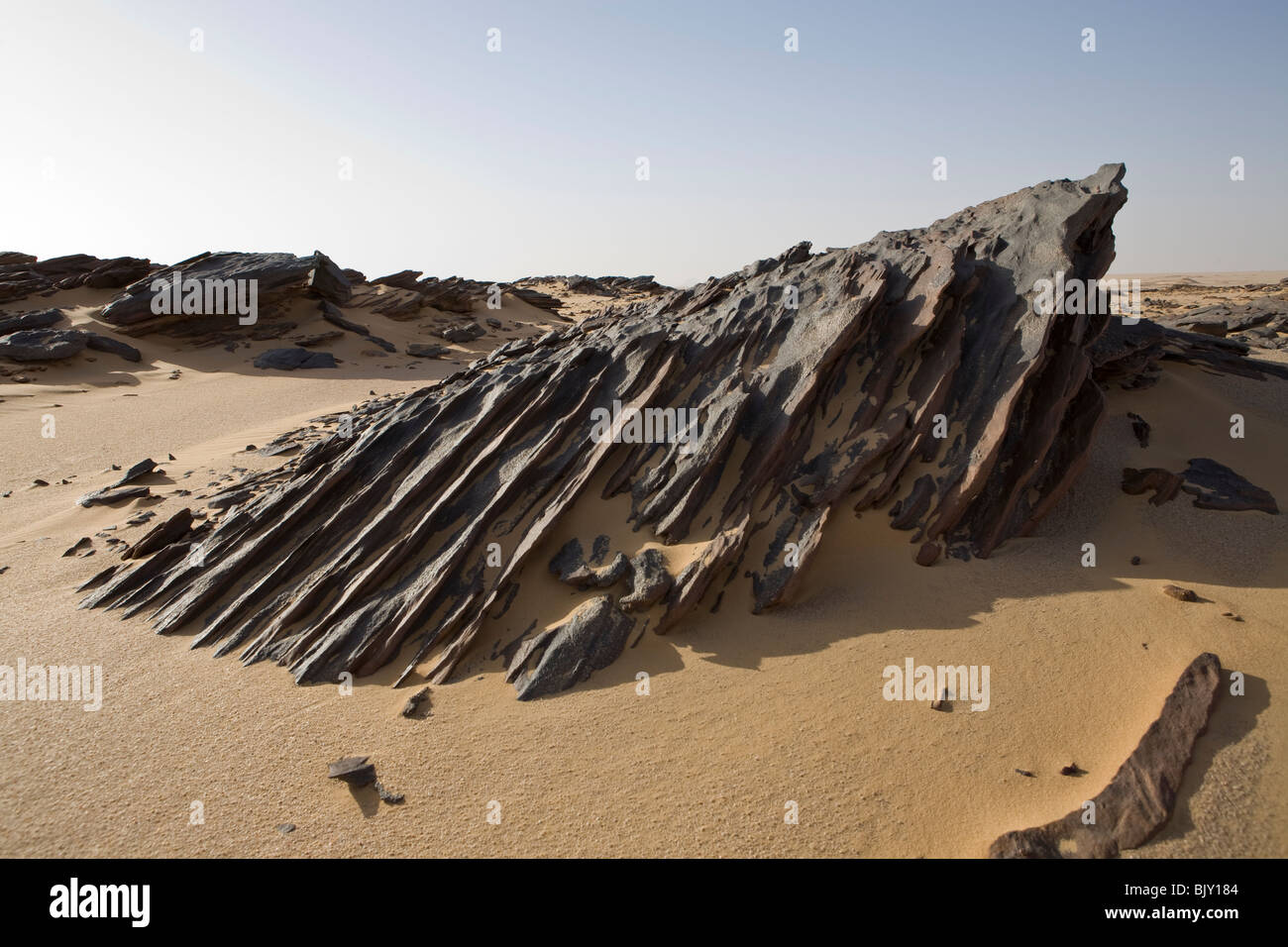 Black rocks in desert floor within the Gilf Kebir National Park ...