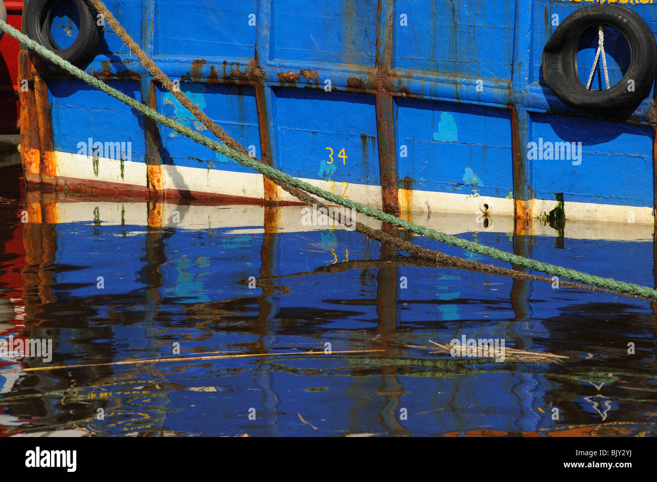 Bold colours blue and white reflections of fishing boat hulls ...