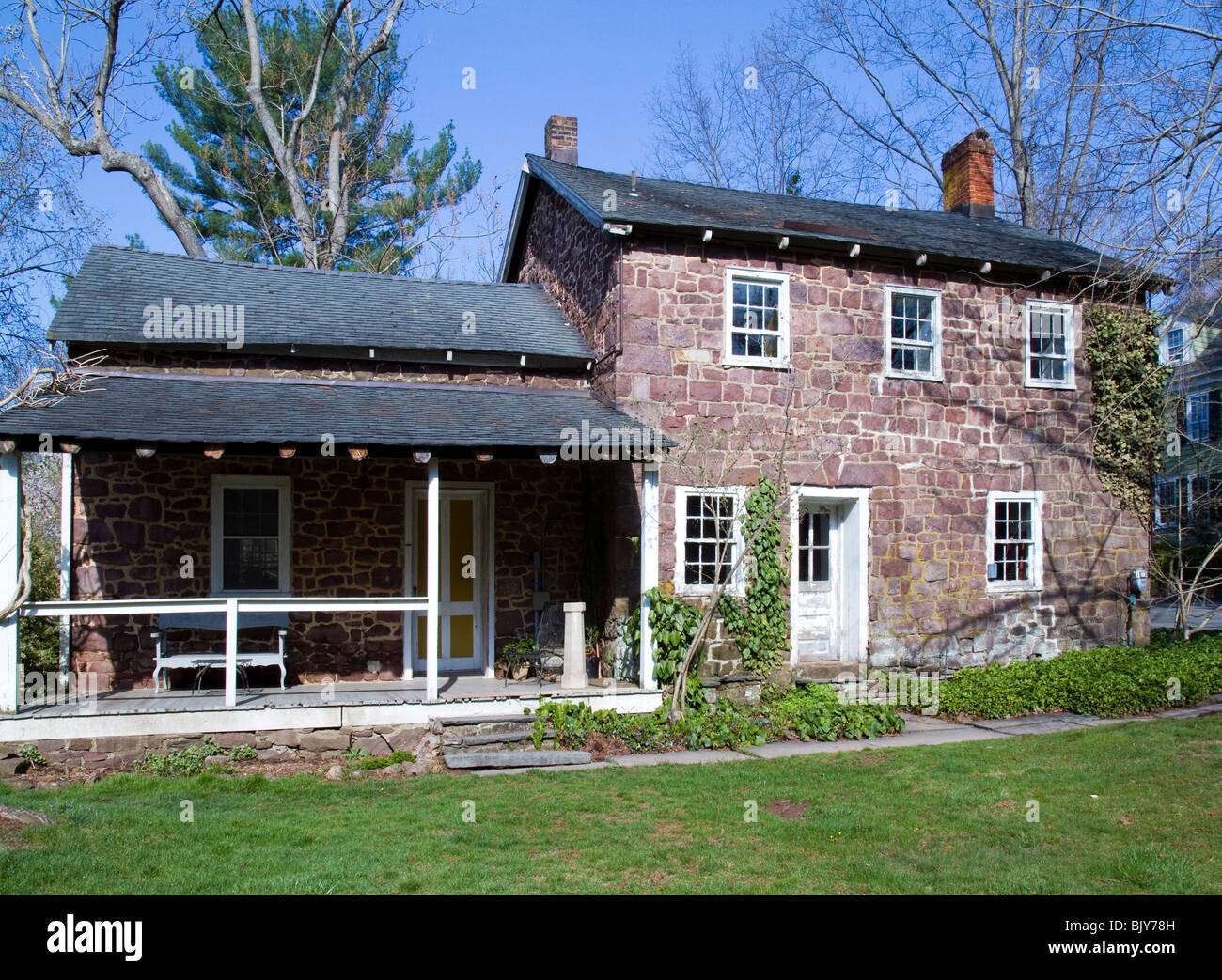 The gable end of a country cottage with ceder shakes stone chimney and ...