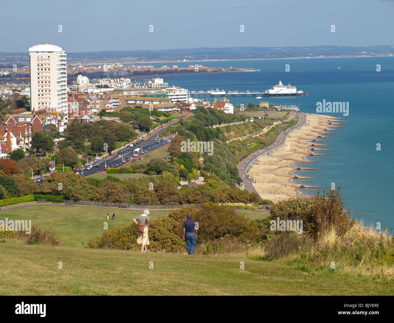 View of Eastbourne Seafront and Pier from South Downs Way with walkers ...