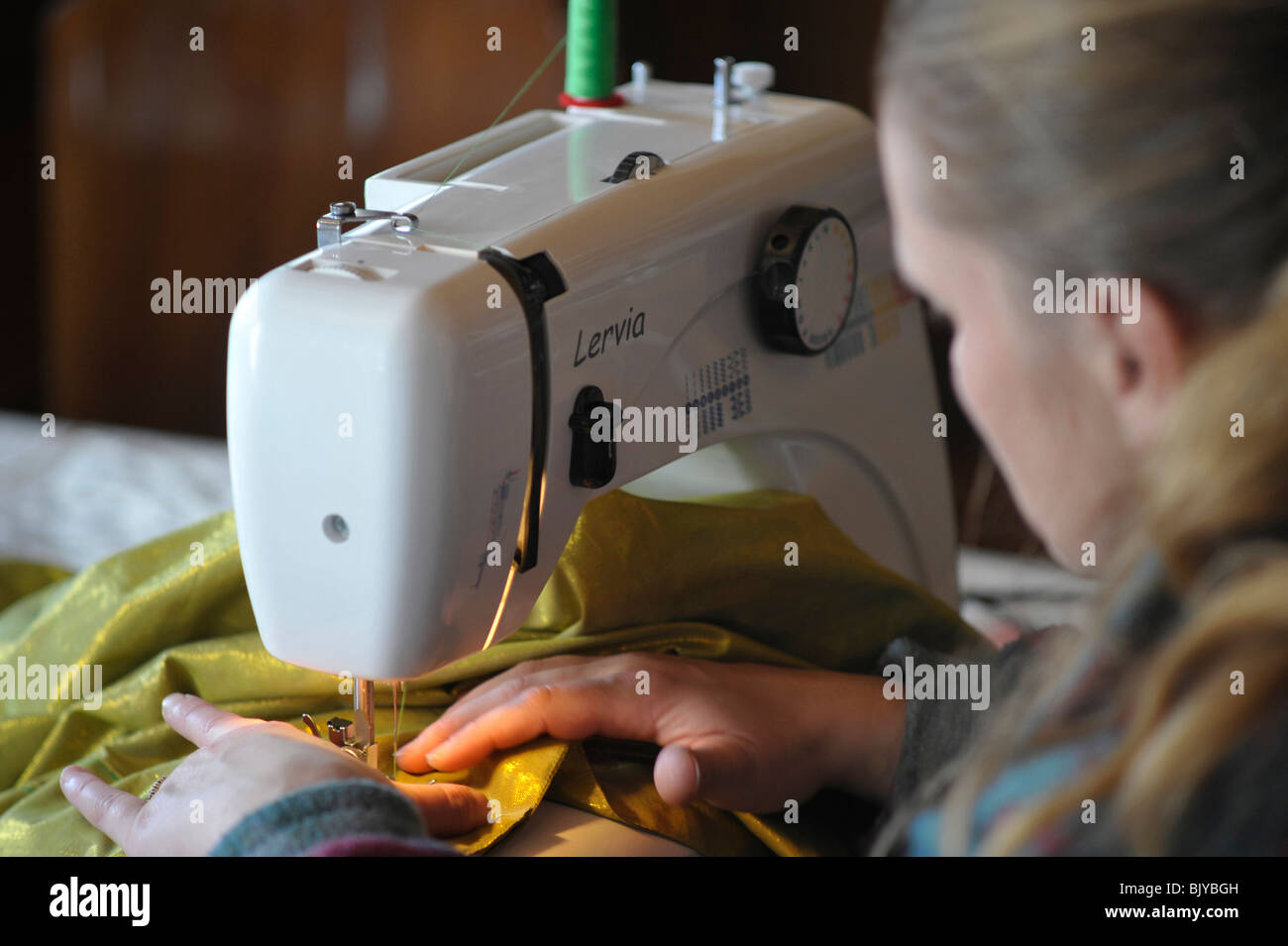 Woman using a sewing machine Stock Photo - Alamy