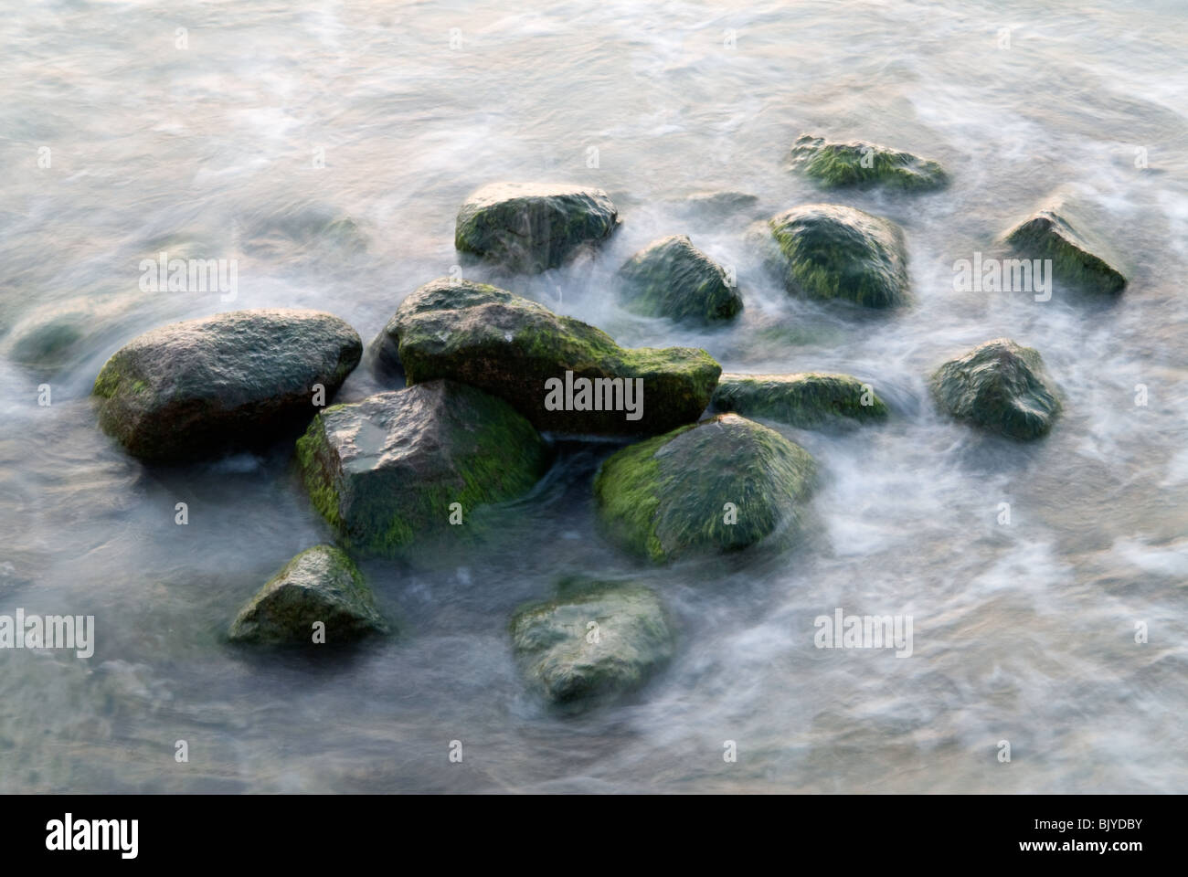 Stones in moving water Stock Photo - Alamy