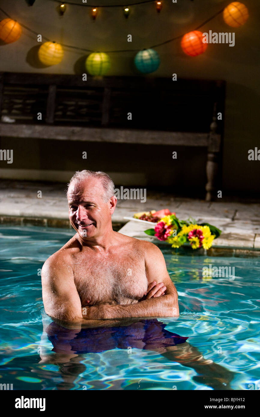 Smiling mature man standing in pool with arms folded Stock Photo - Alamy