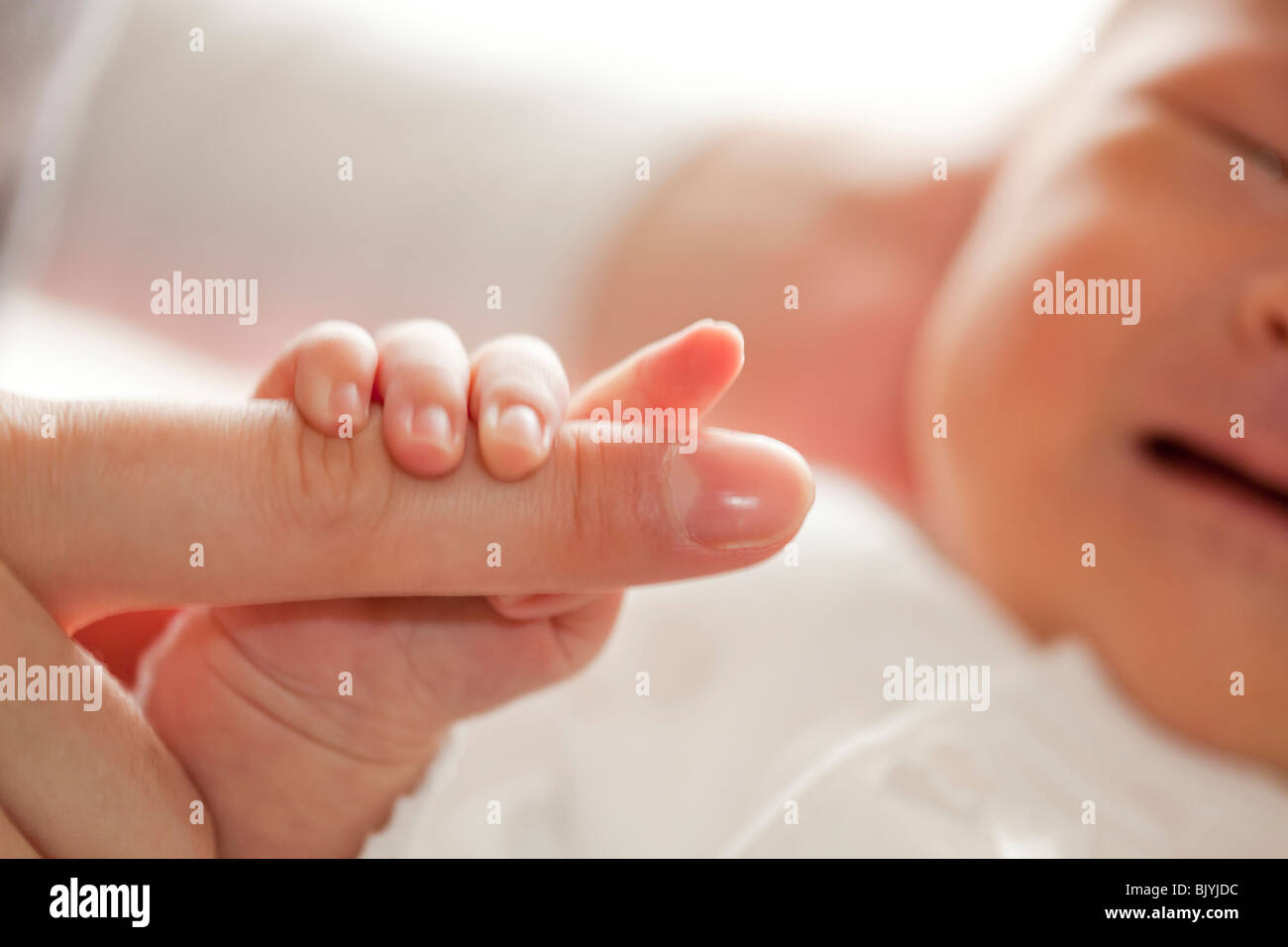 Newborn baby holding mother's finger Stock Photo - Alamy