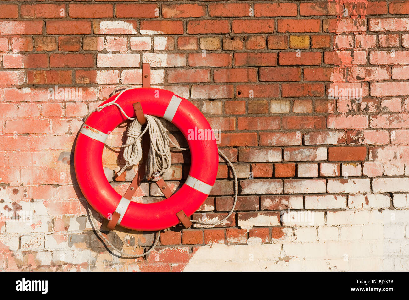 Orange lifebelt on bracket against brick wall Stock Photo - Alamy