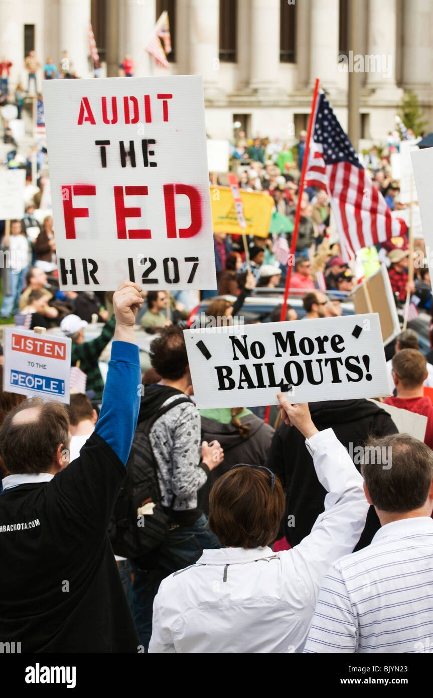 A group of people display signs and American flags at a Tea Party Rally ...
