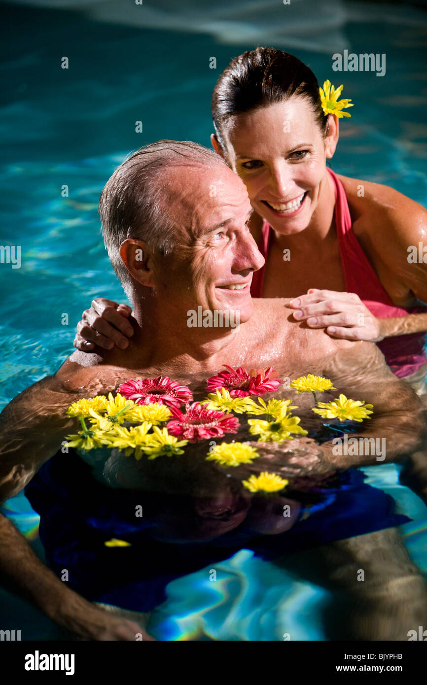 Romantic couple in swimming pool surrounded by floating flowers Stock ...
