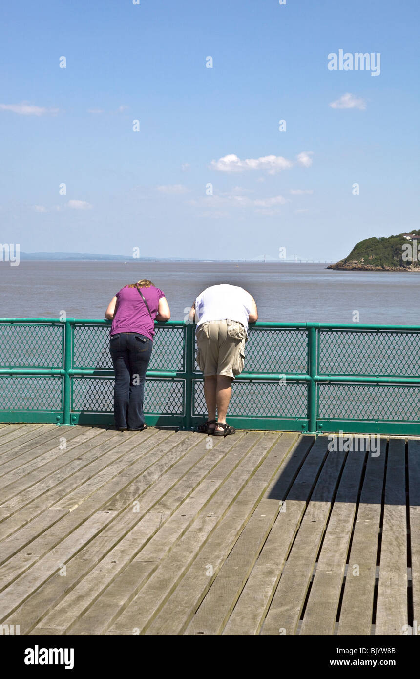 couple looking over the railings on clevedon pier Stock Photo - Alamy