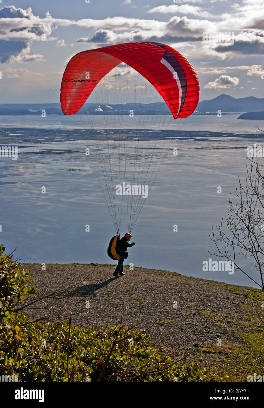 This vertical image shows a person getting ready to jump off a cliff ...