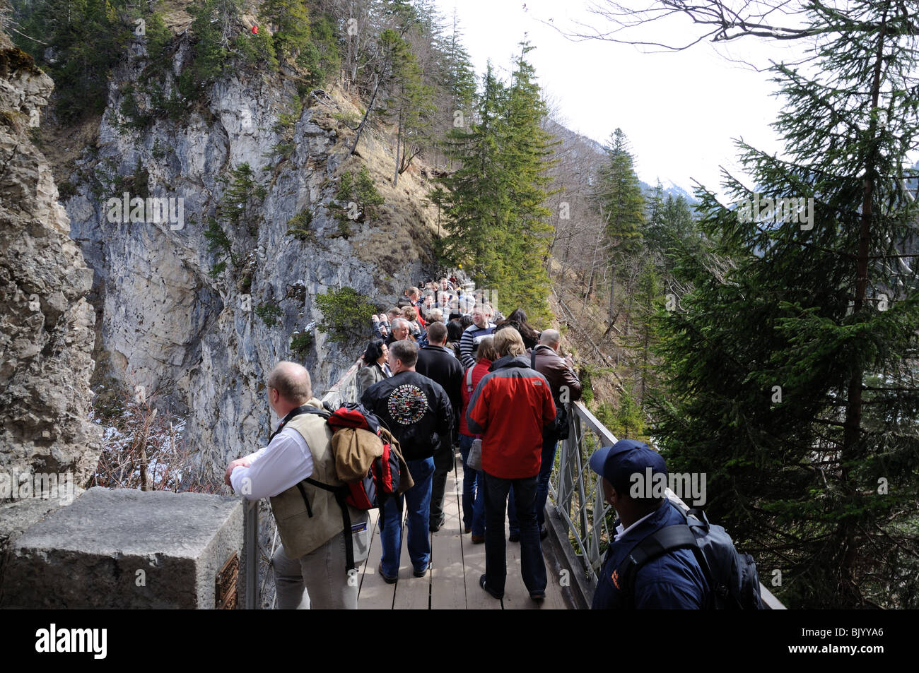 Tourists watching castle Neuschwanstein from the Marien-Bridge. Bavaria ...