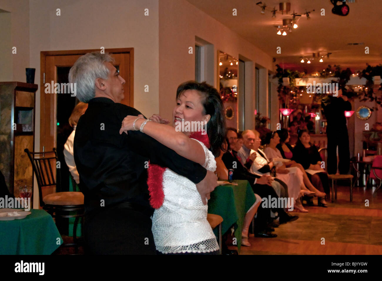 This mature nice looking non-Caucasian couple are dancing a waltz in a ...