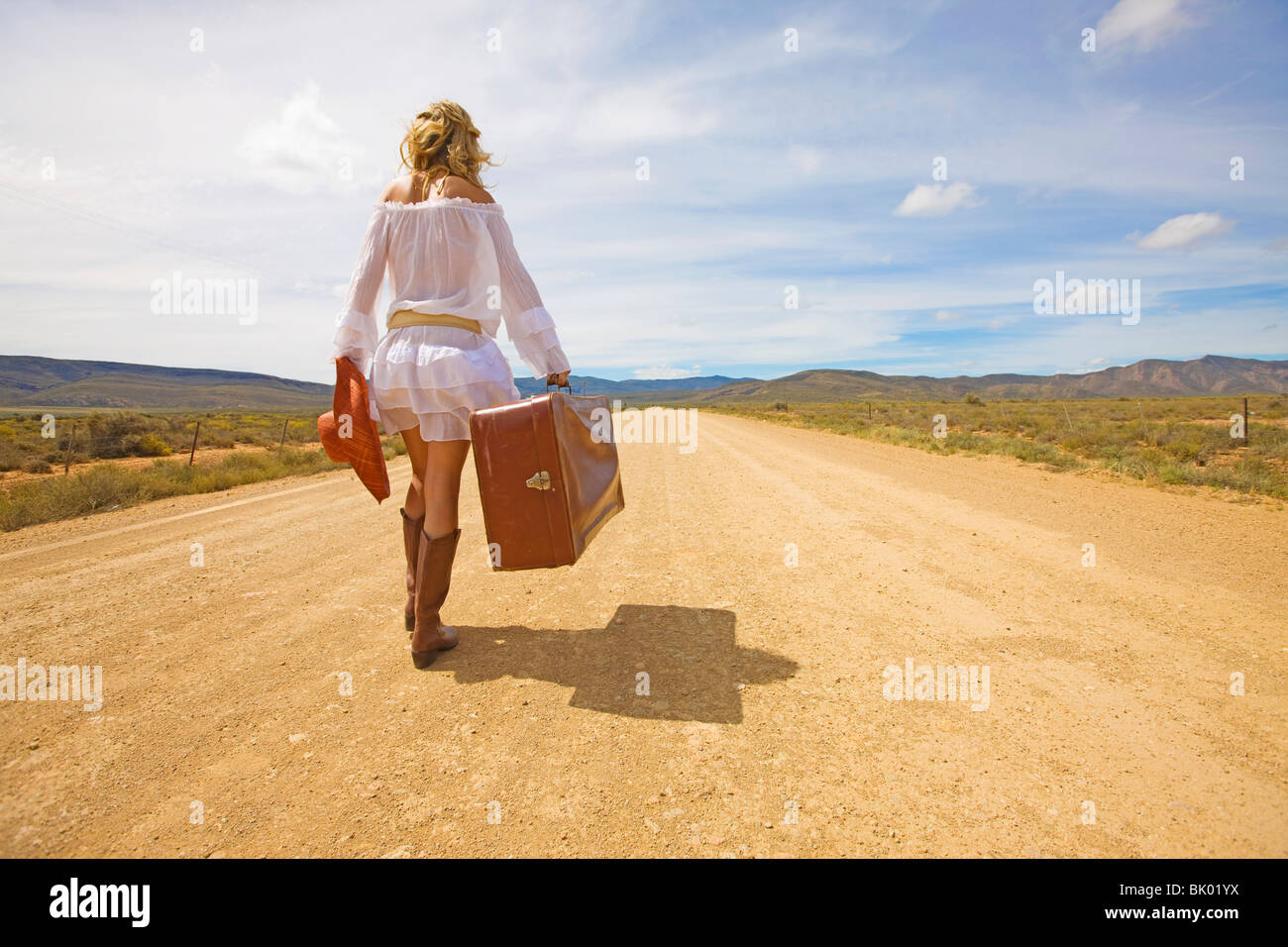 Lonely woman on desert road Stock Photo - Alamy