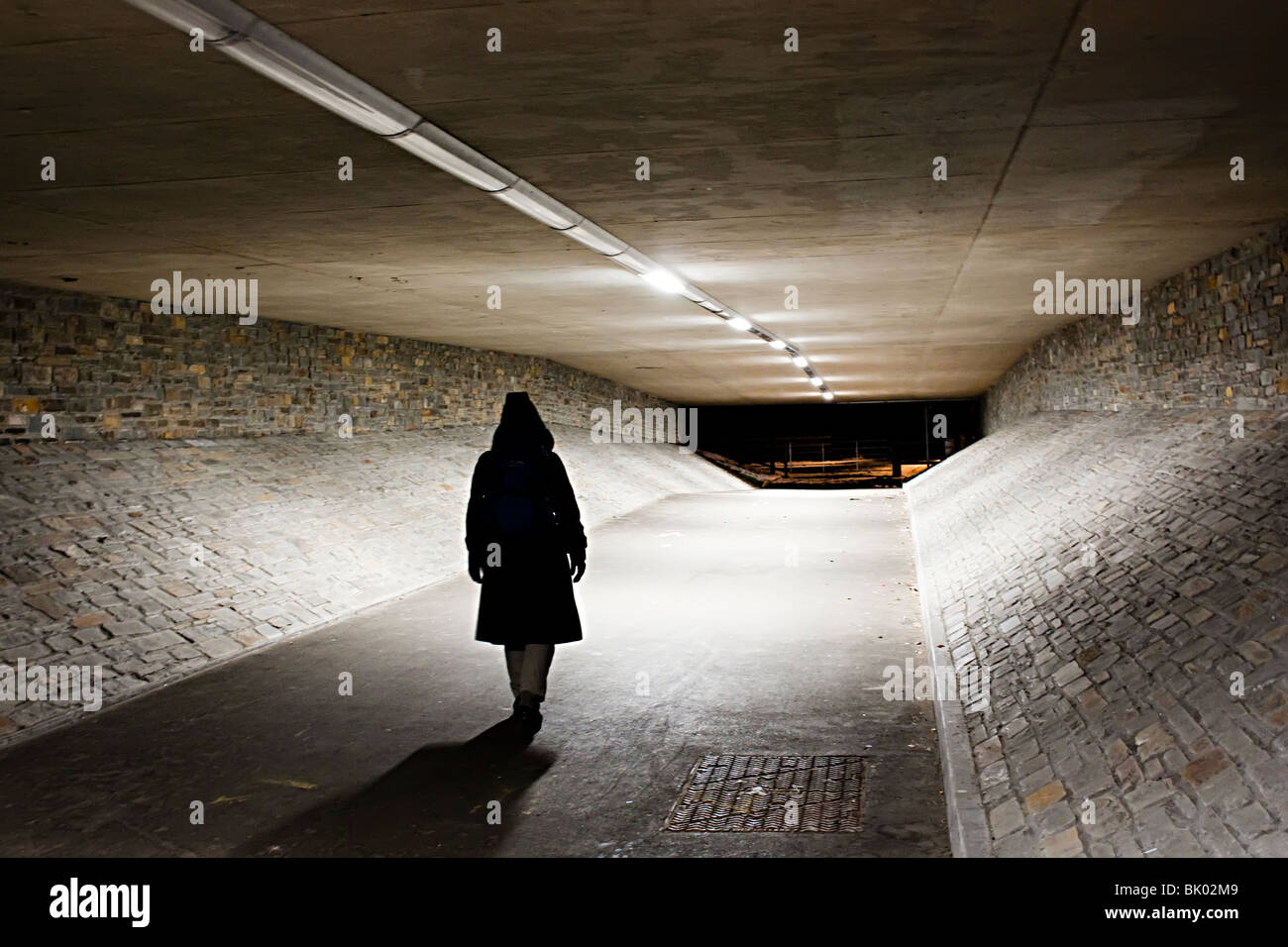 Woman walking alone through underpass at night Abergavenny Wales UK ...