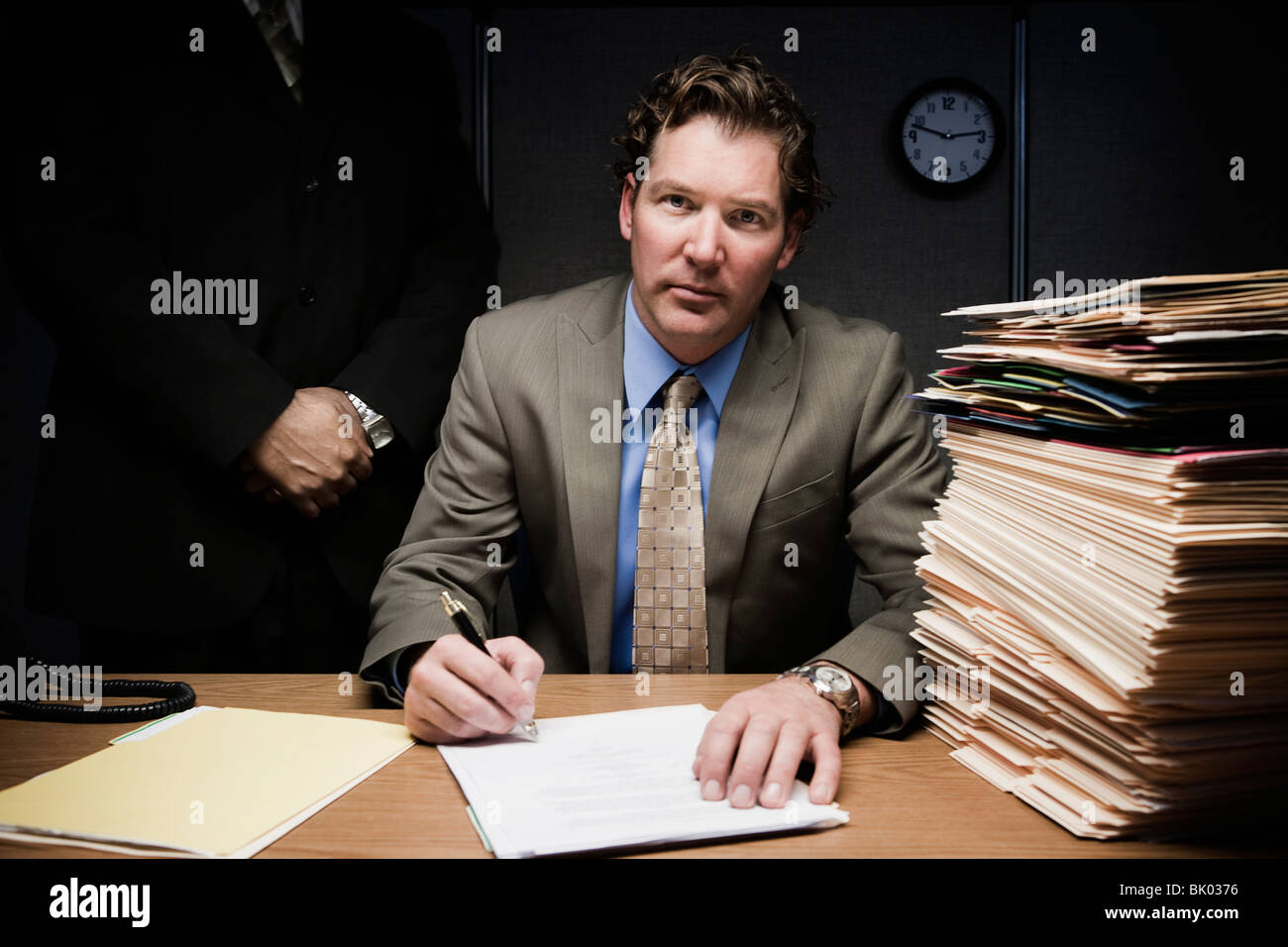 Man doing paperwork with man behind him Stock Photo - Alamy